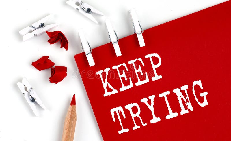 KEEP TRYING Text on Red Paper with Office Tools on White Background ...
