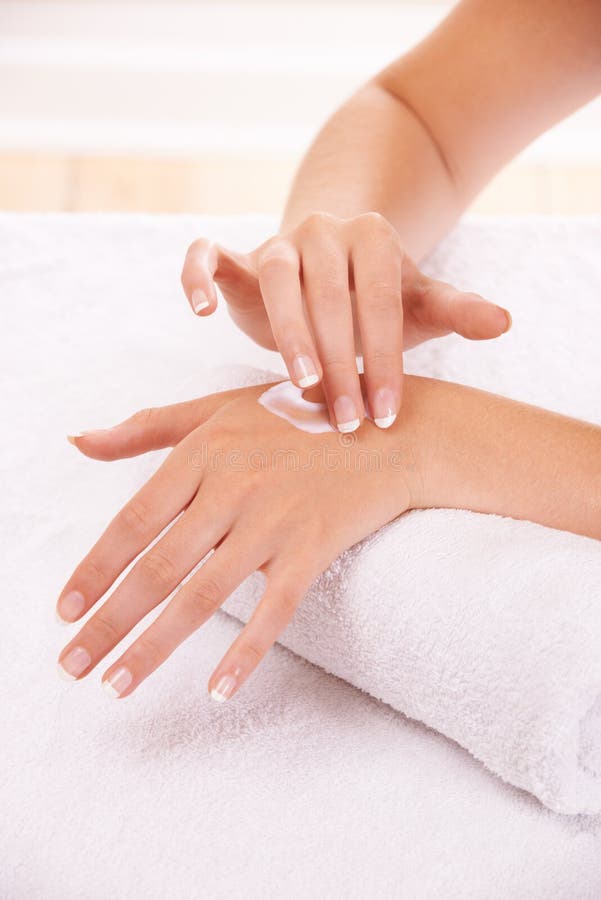 Keeping Her Hands Silky Smooth. a Woman Applying Lotion To Her Hands ...