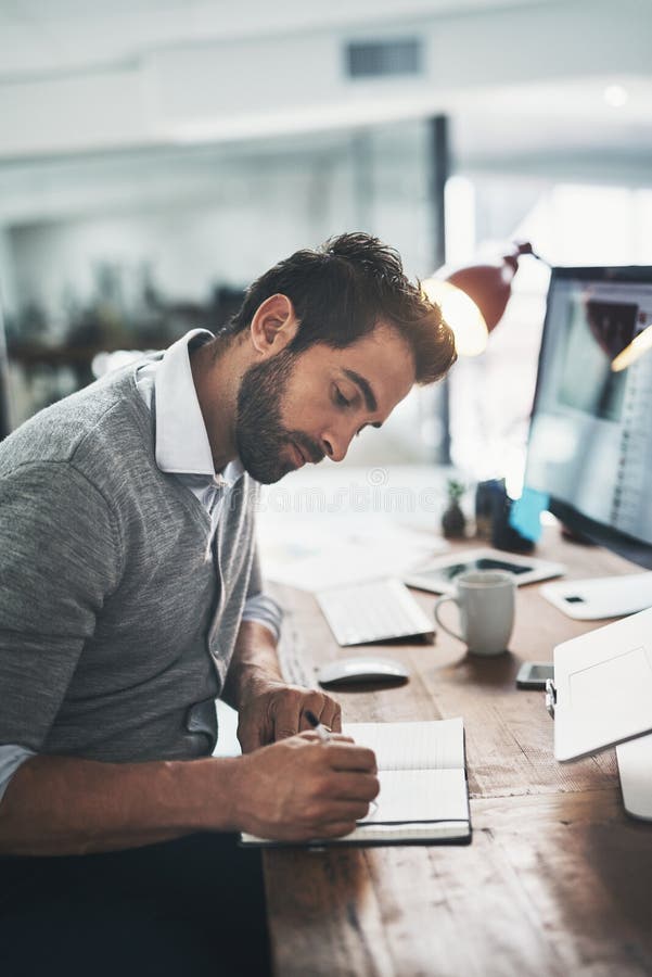 Keeping Notes As he Stays on Top of His Work. a Young Businessman ...