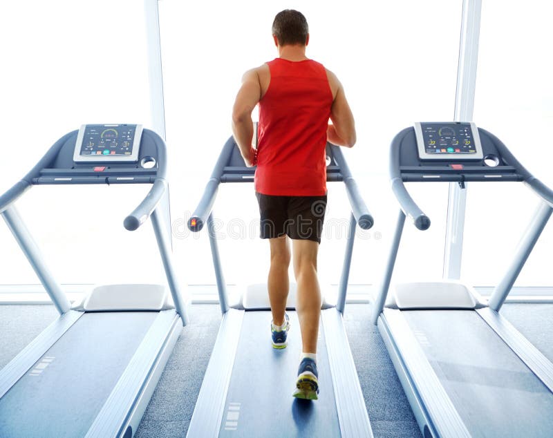 Keeping a Steady Pace. a Handsome Young Man Exercising on a Treadmill ...