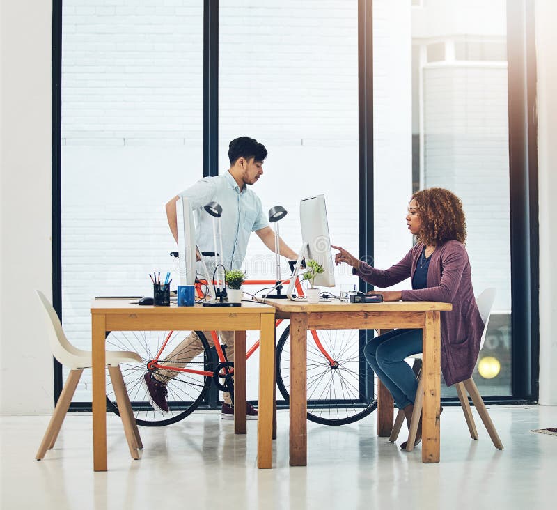 Keeping Things Green in the Office. Two Creative Colleagues Working Together in Their Office ...