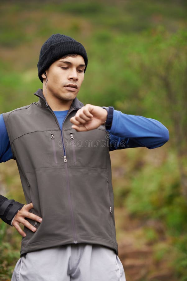 Keeping Time. a Handsome Young Trail Runner Checking the Time on His ...