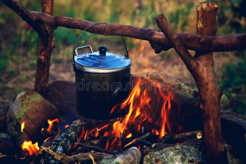 Travel a Kettle Over a Fire Burning on the River and Sunset Backgroun ...