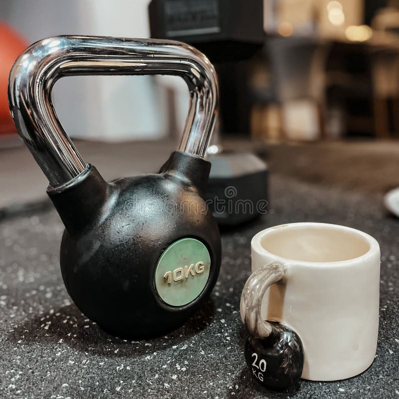 Kettlebell Next To a White Ceramic Mug with Kettlebell Design in a Gym ...