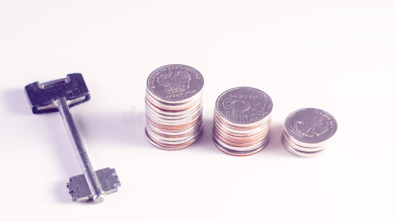 A Key is on a Table with a Pile of Coins Stock Photo - Image of ...