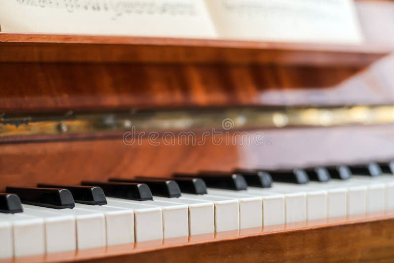 The Keyboard of a Brown Upright Piano with Sheet Music. Stock Photo ...