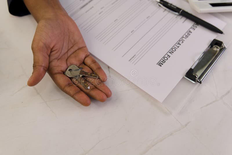 Keys Held in Hand Above Rental Application Paperwork Stock Photo ...