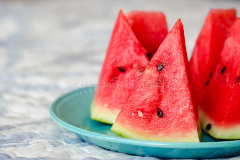 Watermelon Cut into Triangular Pieces on a Blue Plate Stock Photo ...