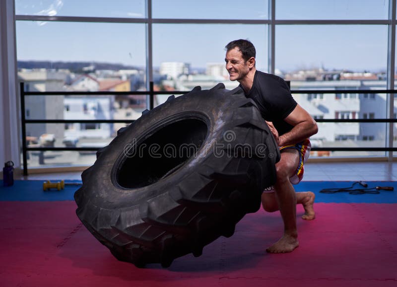 Kickboxer Doing Tire Flips in the Gym Stock Photo - Image of muay ...