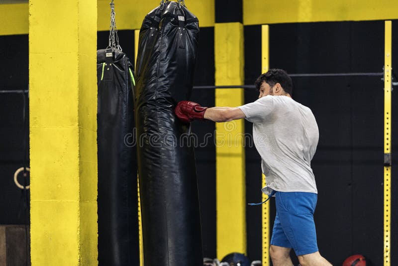 Kickboxing Fighter Performing Punches on Punching Bag at the Gym Stock ...