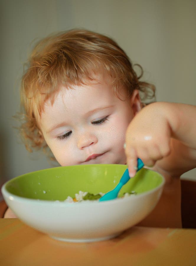 Kid Baby Eat Soup in the Kitchen with Dishes and Spoon. Stock Photo ...