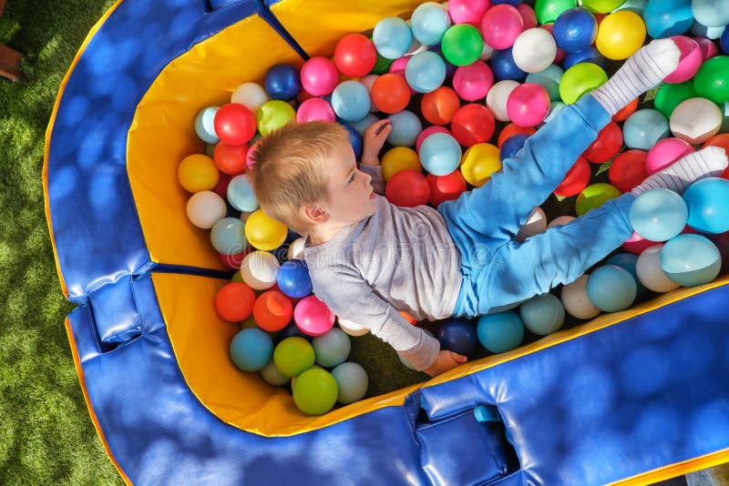 Kid in ball pit having fun stock image. Image of childhood - 143820761