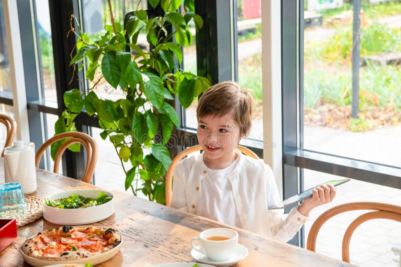 A Kid at Dinner Table with a Tablet Stock Image - Image of small ...