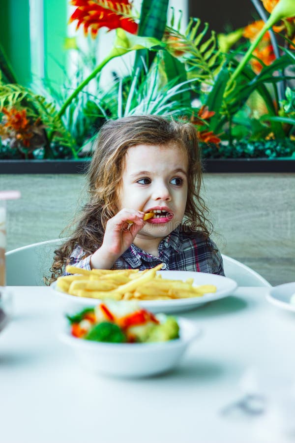 Kid Girl in a Restaurant Eating Fast Food. Stock Image - Image of eyes ...
