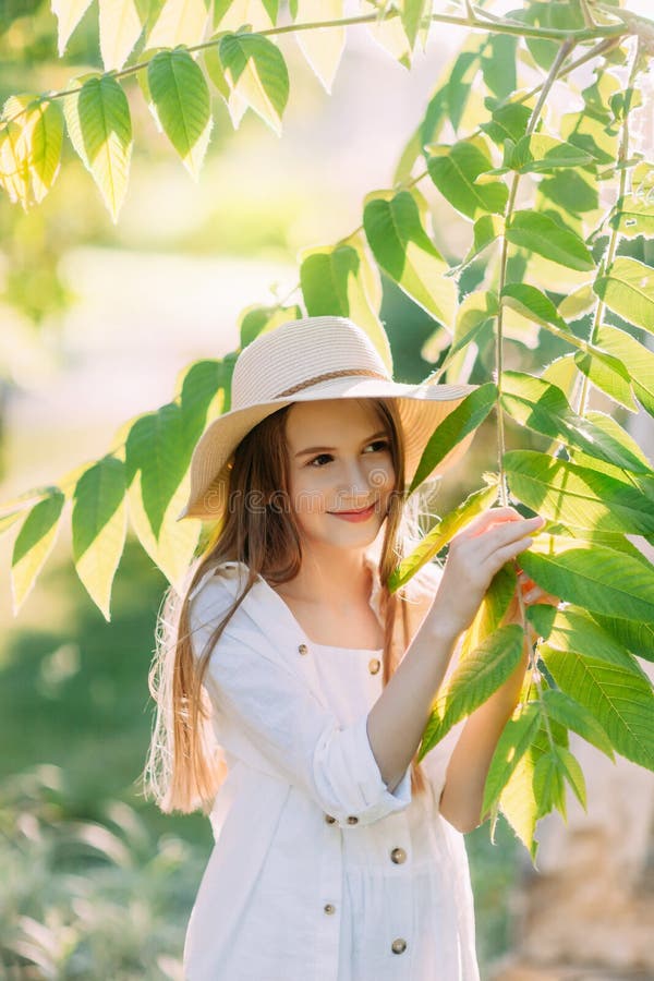 Beautiful Girl in White Dress and Retro Hat Smiling and Hide Under Tree ...