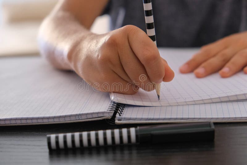 Kid Hand Learning, Writing School Homework on Paper Notebook. Close Up ...