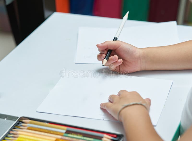 Kid Hands Holds Color Pencil and Think about Writing Things on W Stock ...