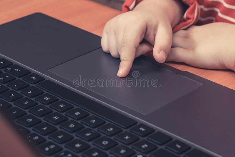 Kid Hands on Laptop Touchpad, Child Learns and Plays on Computer Stock ...