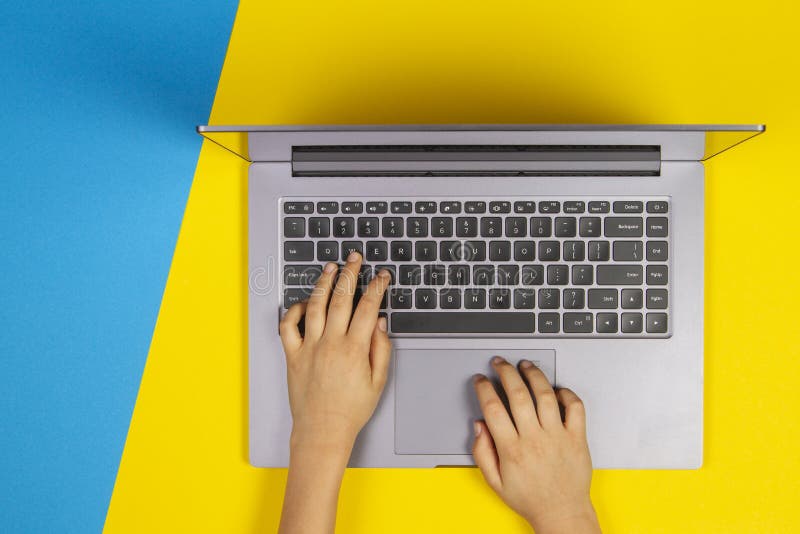 Kid Hands Typing on Laptop Computer Keyboard, Top View, Yellow and Blue ...