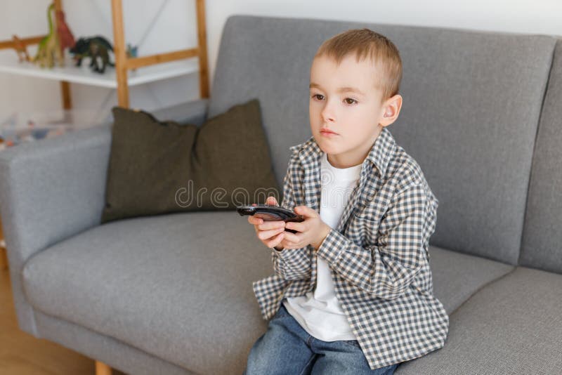 Kid Holding TV Remote Controller. Boy without Parental Control Watching ...