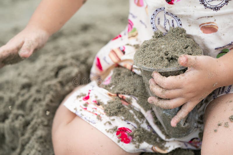 A Boy Plays with Sand and Builds Sand Castles on the Seashore Stock ...