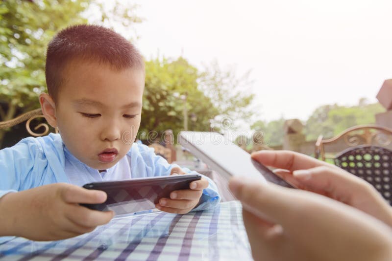 Kid indulge in smartphone stock image. Image of outdoor - 77255997