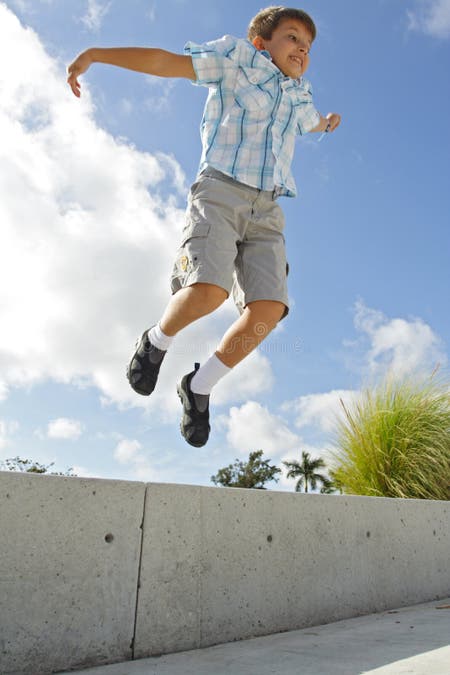 Kid jumping from a ledge stock image. Image of youth, outdoors - 4088507