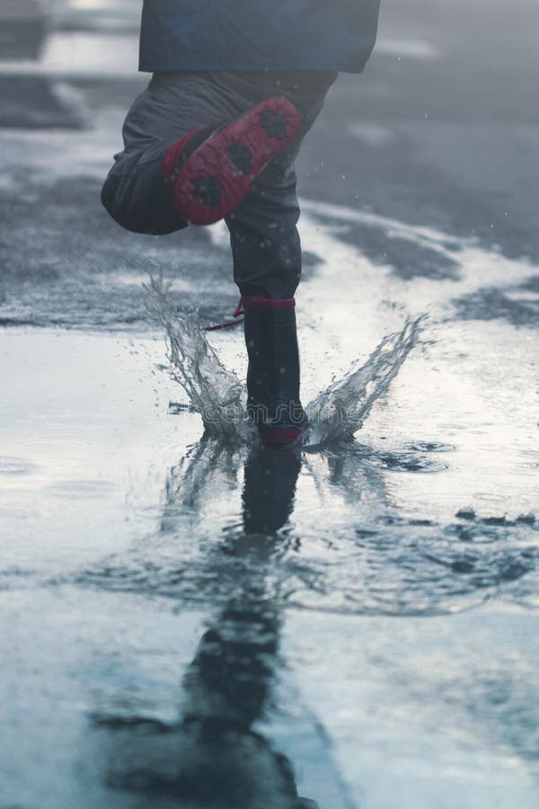 Kid jumping in puddles stock photo. Image of girl, happy - 94393566