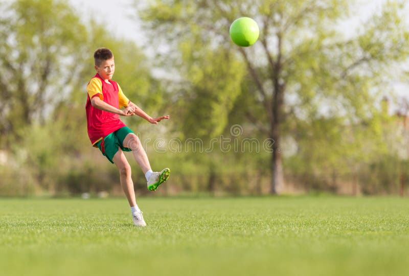 Kid kicking a soccer ball stock image. Image of color - 69561299