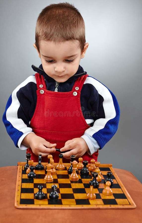 Kid learning to play chess stock image. Image of table - 41477433