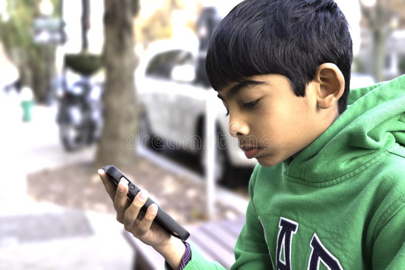 A Kid is Looking at His Smart Phone in a Street Stock Image - Image of ...