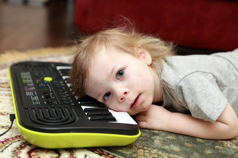 Kid Lying and Playing on Synthesizer Stock Photo - Image of male, lying ...