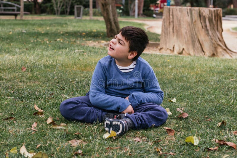Kid with Multiple Disabilities Relaxing Outdoors Sitting on a Grass in ...