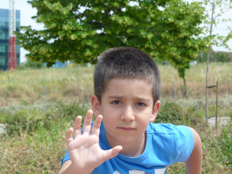 Kid in a Park Greeting with His Right Hand Stock Photo - Image of ...