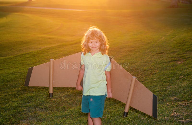 Kid Pilot with Backpack Wings at Sunset Grass Field. Child Playing ...