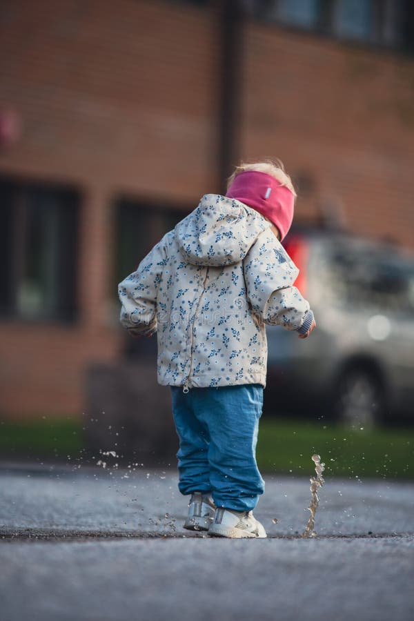 Kid Playfully Jumping into the Puddle Stock Image - Image of feet ...
