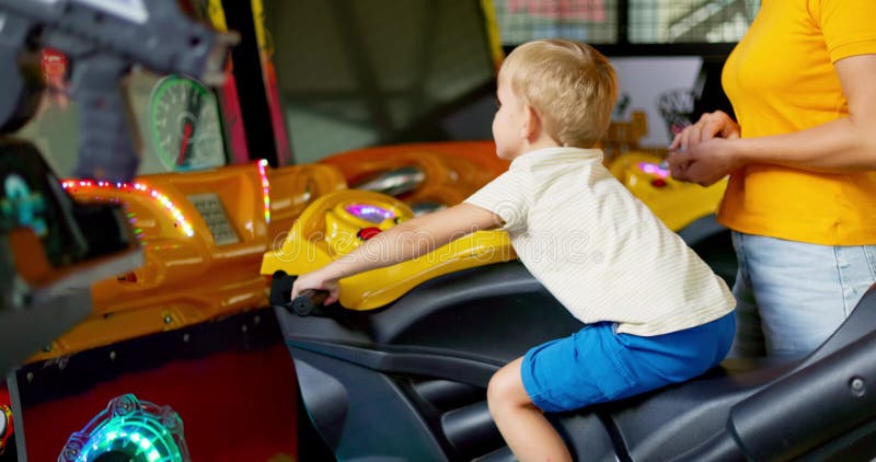 Kid Playing Arcade Simulator Machine at an Amusement Park Stock Video ...