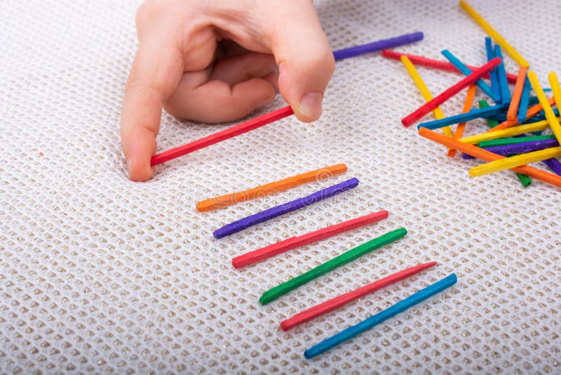Kid Playing with Coloured Wooden Sticks for Creativity Stock Photo ...