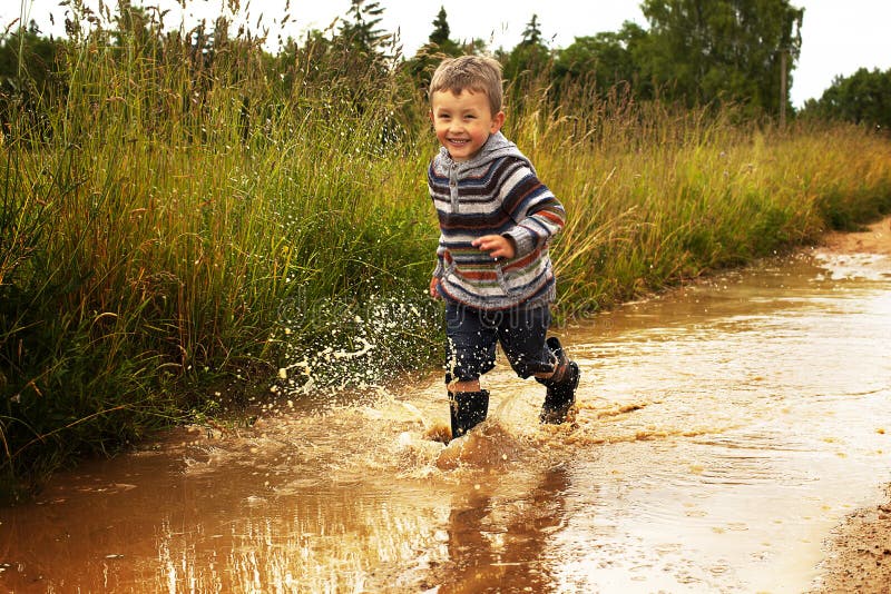 Kid playing in puddle stock image. Image of action, fall - 60072917