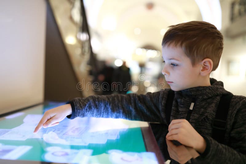 Kid Playing Puzzles on Touch Screen in Entertainment Center Stock Image ...