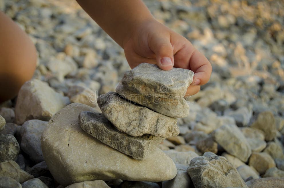 Kid playing with stones stock photo. Image of hand, stones - 64752474