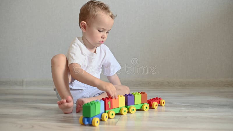 The Kid is Playing a Train with Trailers from the Constructor with ...