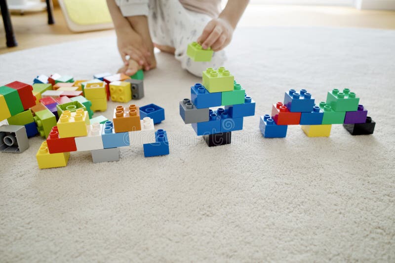 A Kid Plays Building Blocks on a White Carpet. Stock Image - Image of ...
