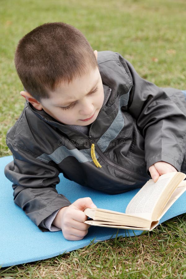 Kid reading book outdoors stock photo. Image of jacket - 19478402