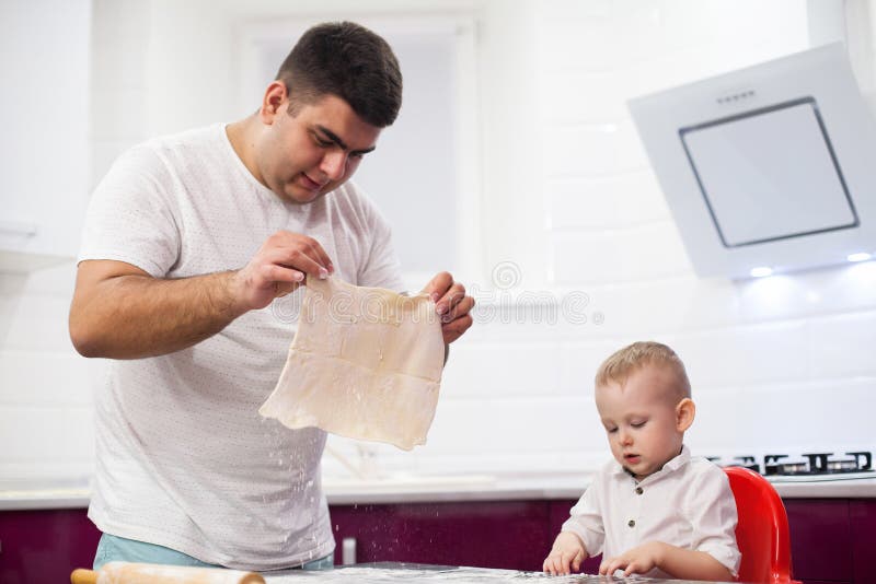 Kid Rolls Out the Pizza Dough. Happy Family in Kitchen Stock Photo ... Kid Rolls Out the Pizza Dough. Happy Family in Kitchen Stock Photo ...
