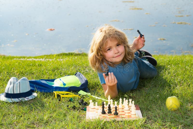 Kid Shows Chess Pieces on a Chessboard. Early Development. Boy Thinking about Chess in Summer ...