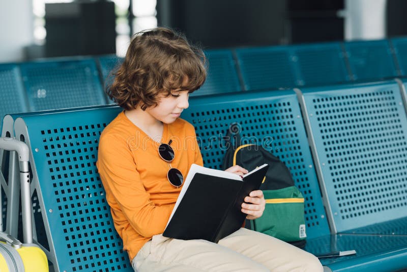 Kid Sitting in Waiting Hall and Writing in Notebook Stock Photo - Image ...