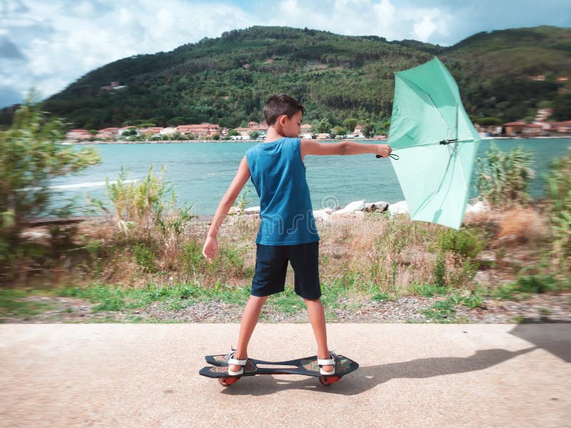 Kid on Skateboard with Wind and Umbrella Stock Image - Image of skater ...