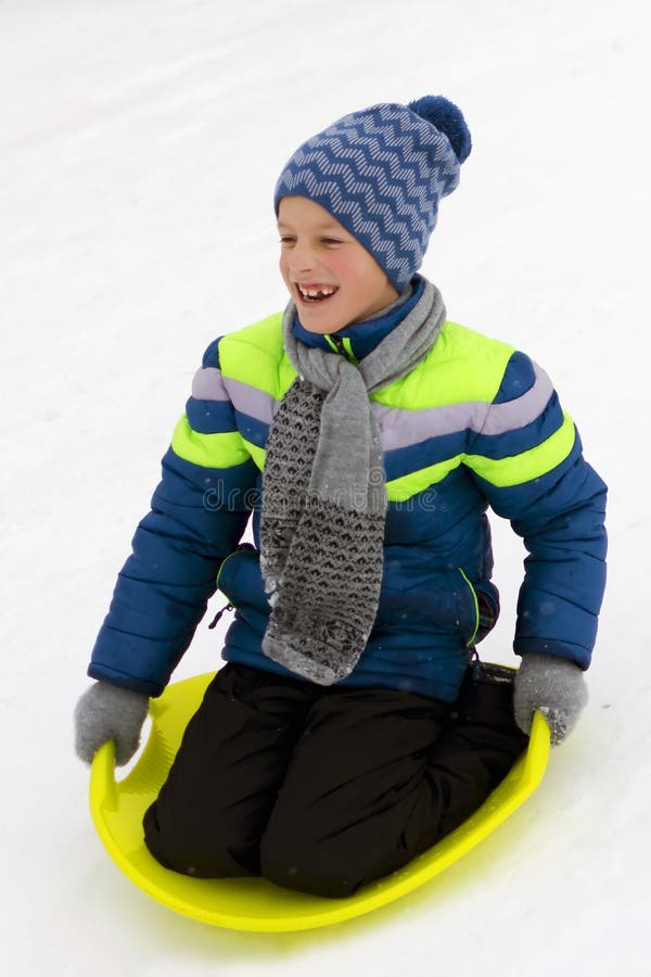 Kid Slides Down a Hill on Plate for Driving on Snow Stock Image - Image ...
