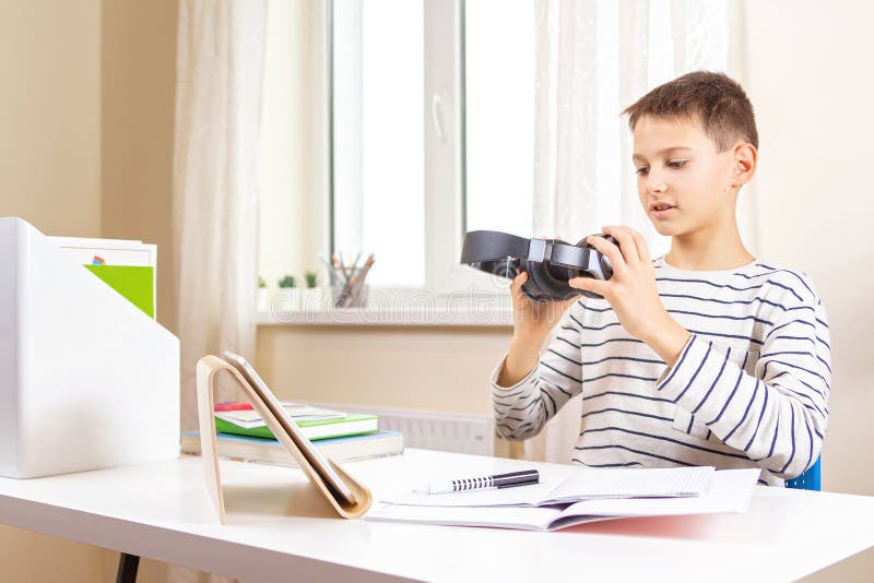 Kid with Tablet Computer Sitting at Table with Books and Having Video ...